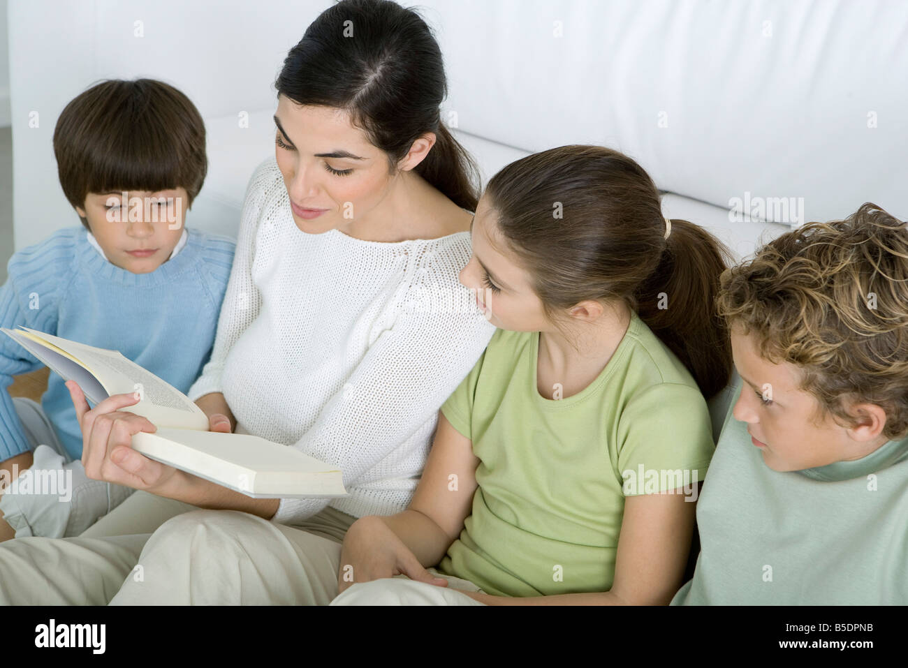 Woman reading story to her children Stock Photo - Alamy