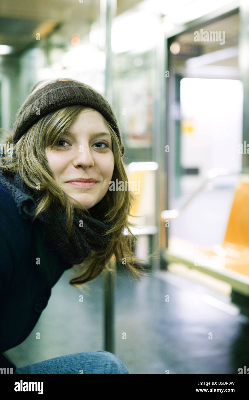 Young woman riding subway, smiling at camera Stock Photo - Alamy
