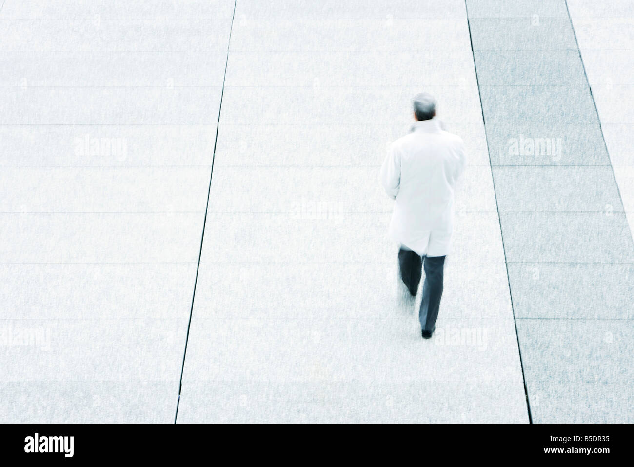 High angle rear view of business man walking down sidewalk Stock Photo ...