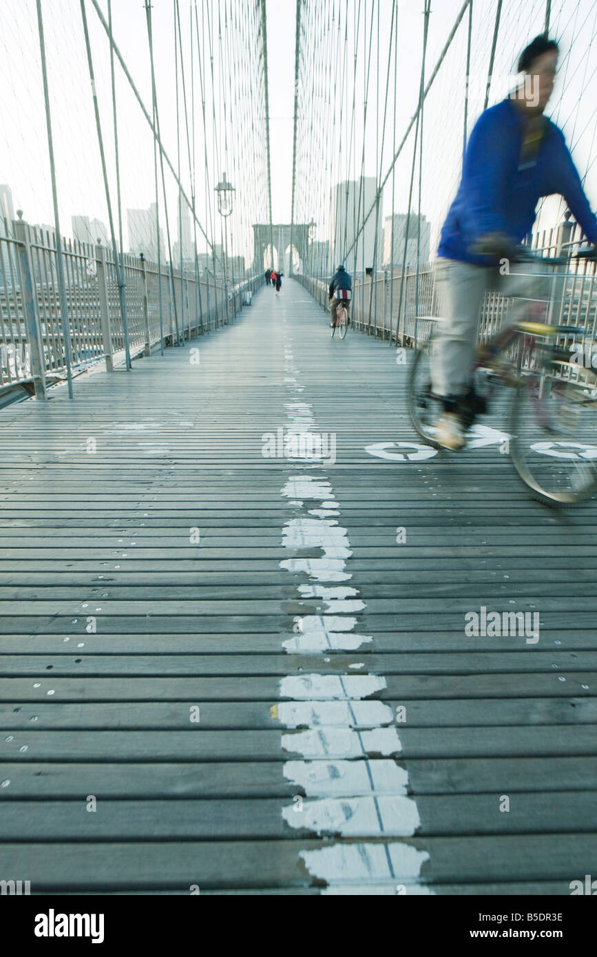 Man riding bike across pedestrian walkway of Brooklyn Bridge in New ...