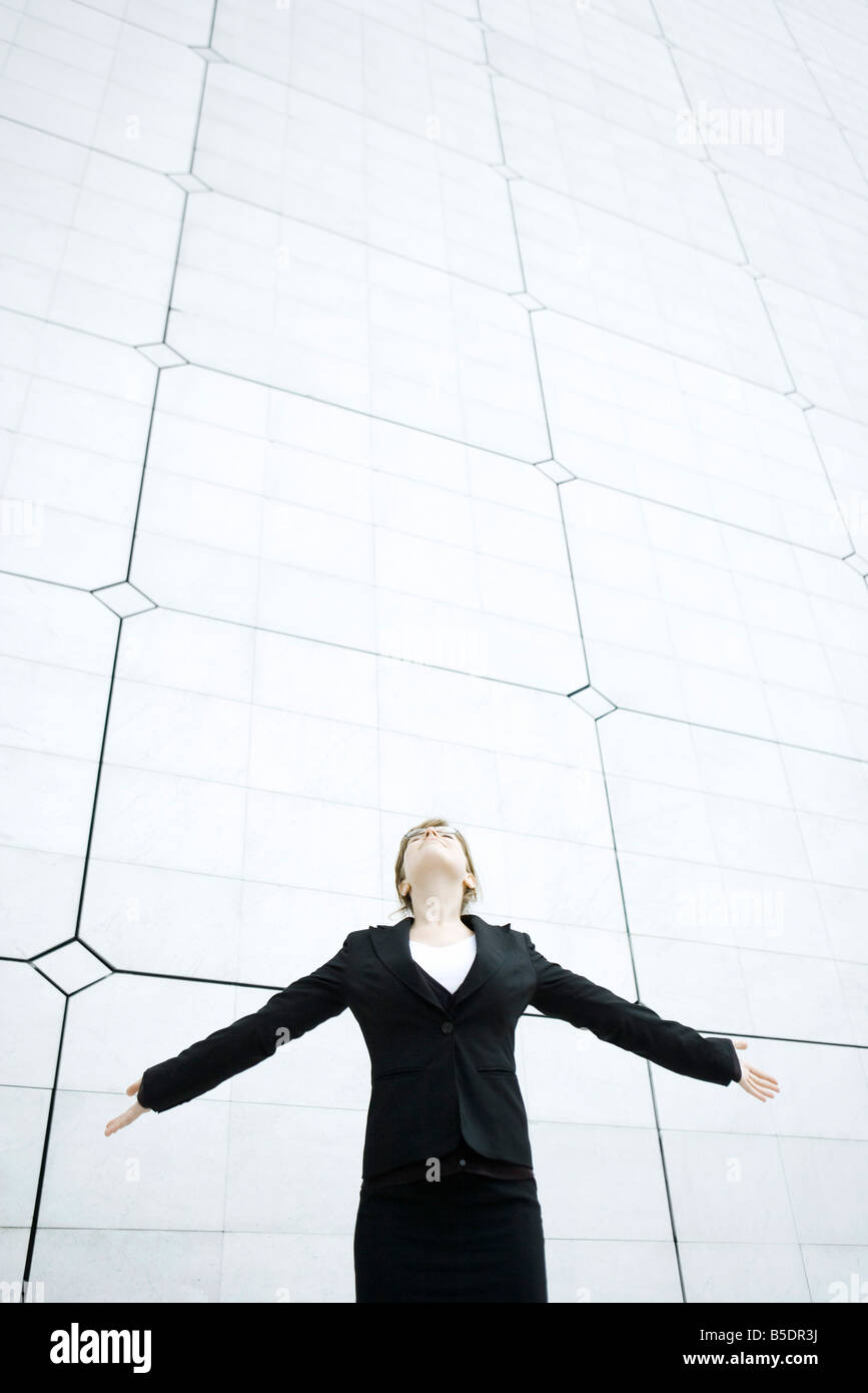 Woman standing with arms outstretched head back looking up Stock Photo ...