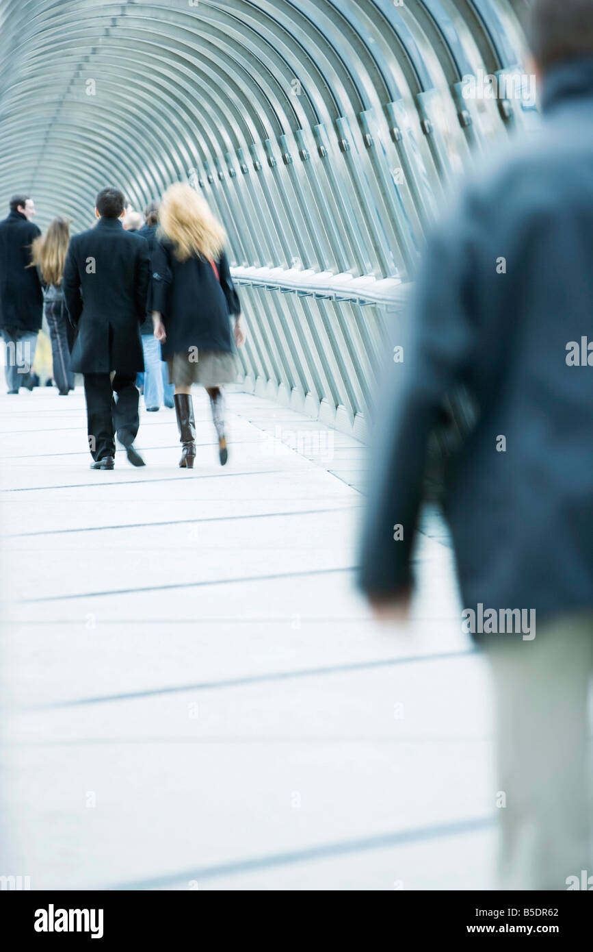 Pedestrians walking across elevated walkway Stock Photo - Alamy