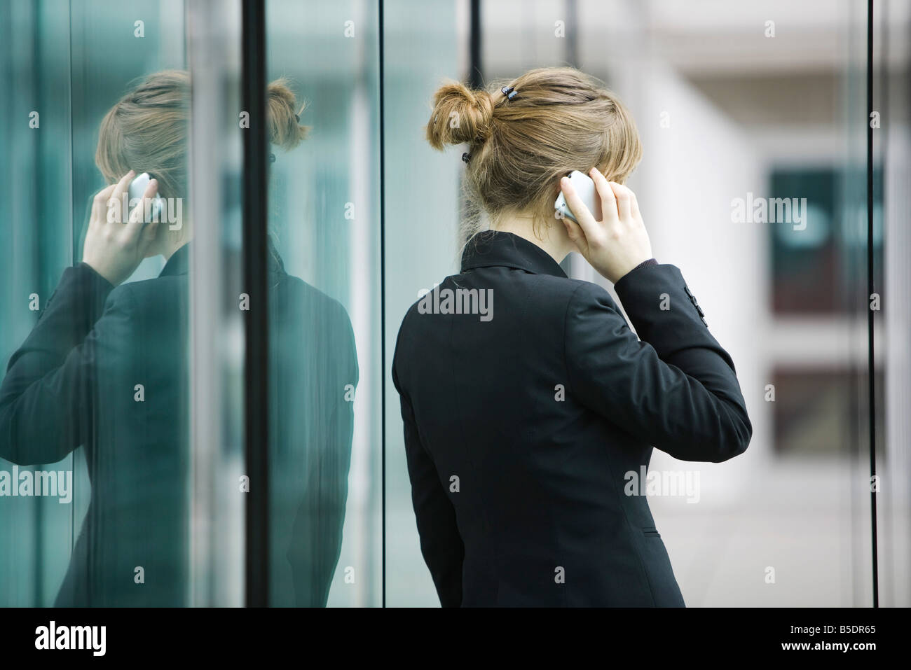 Businesswoman using cell phone, rear view Stock Photo - Alamy