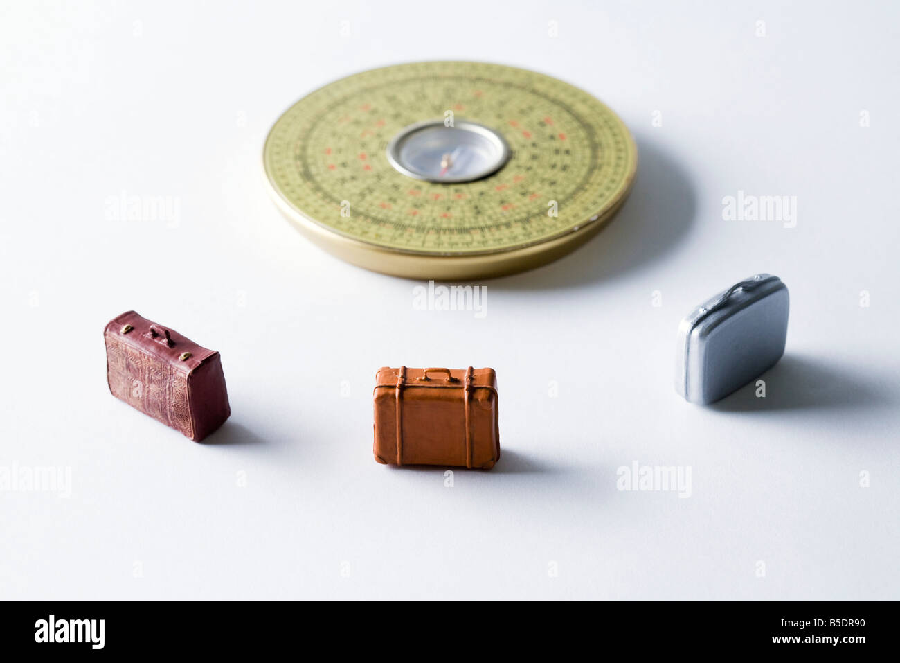 Miniature suitcases arranged around Feng Shui compass Stock Photo - Alamy