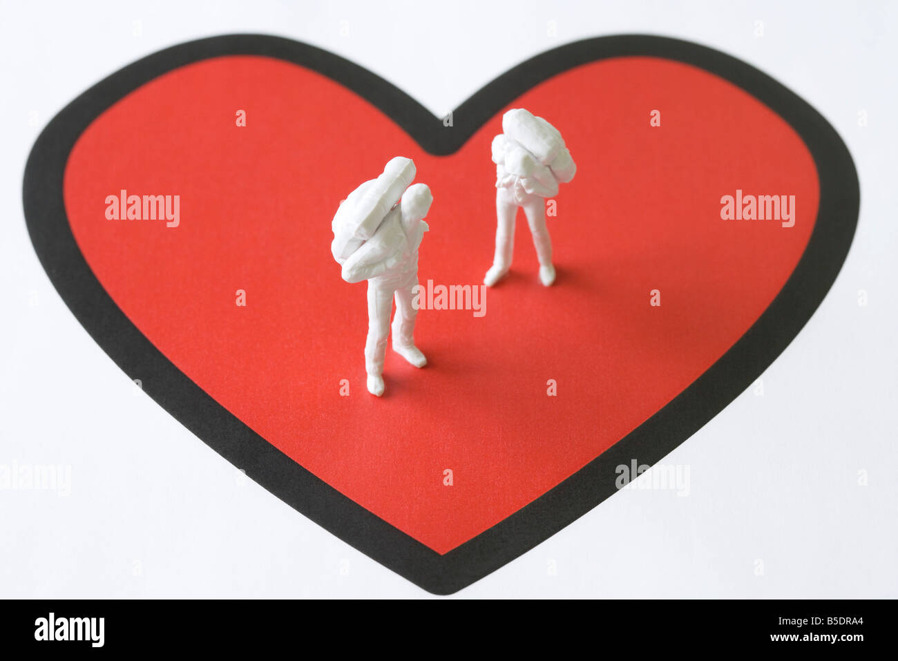 Miniature figures standing on large heart Stock Photo - Alamy