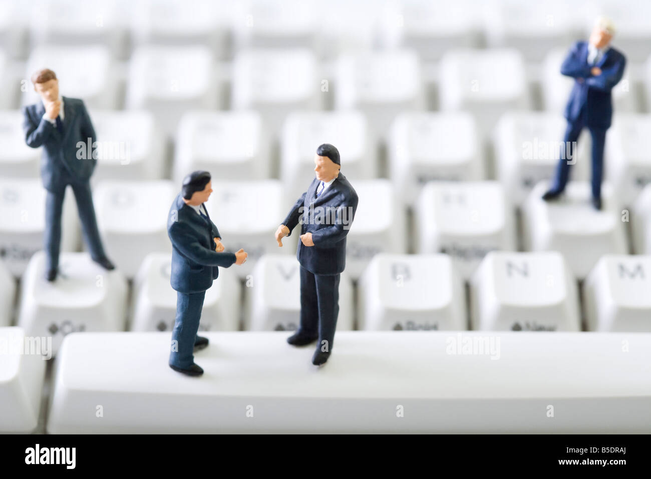 Miniature businessmen standing face to face on computer keyboard Stock ...