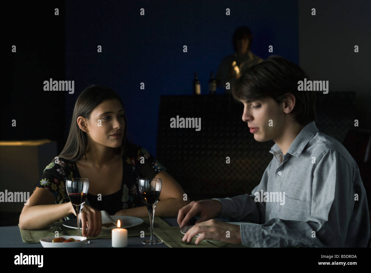Couple having serious conversation over dinner with wine at restaurant ...