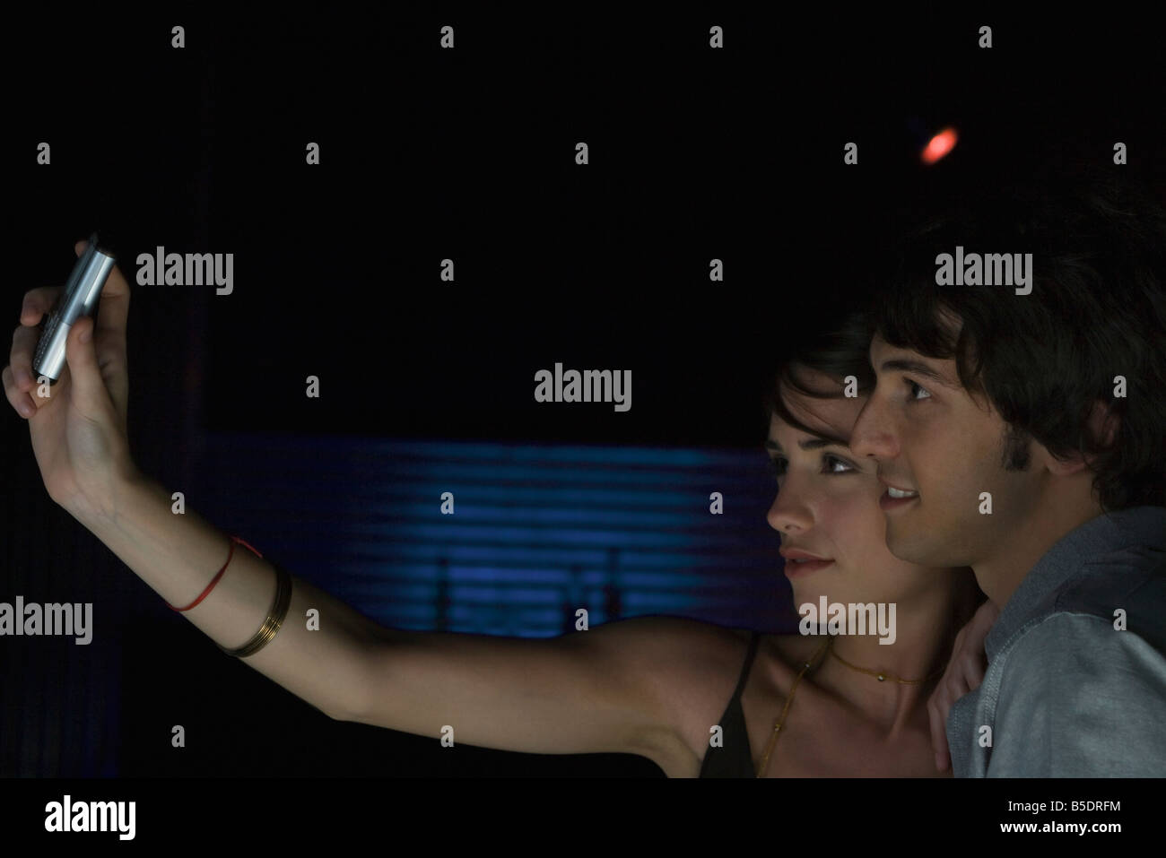 Woman using camera phone to take self portrait of her with date Stock ...