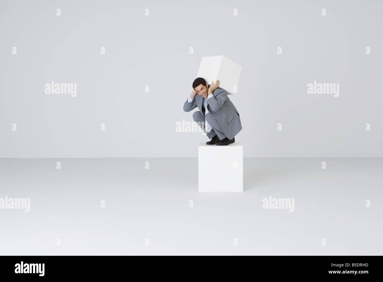 Businessman lifting block on back Stock Photo - Alamy