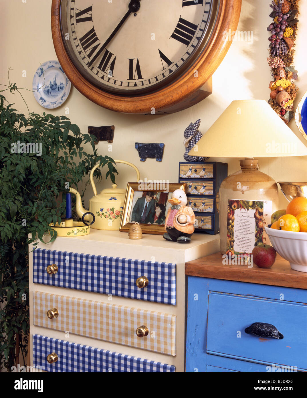 Large circular wall clock above chest of drawers with blue & white ...