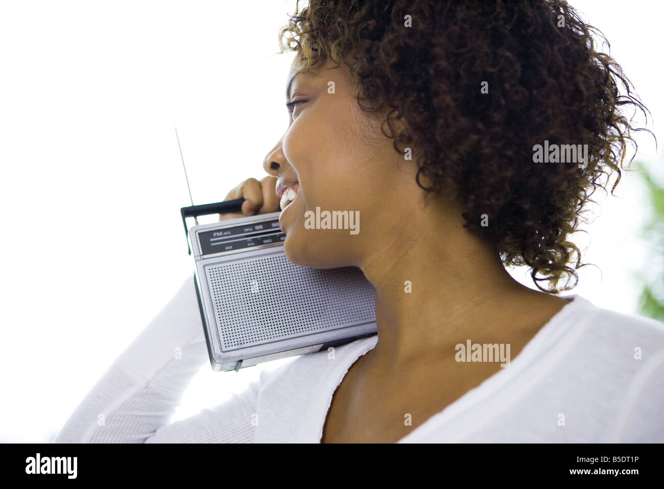 Young woman holding radio on shoulder, smiling, profile Stock Photo - Alamy