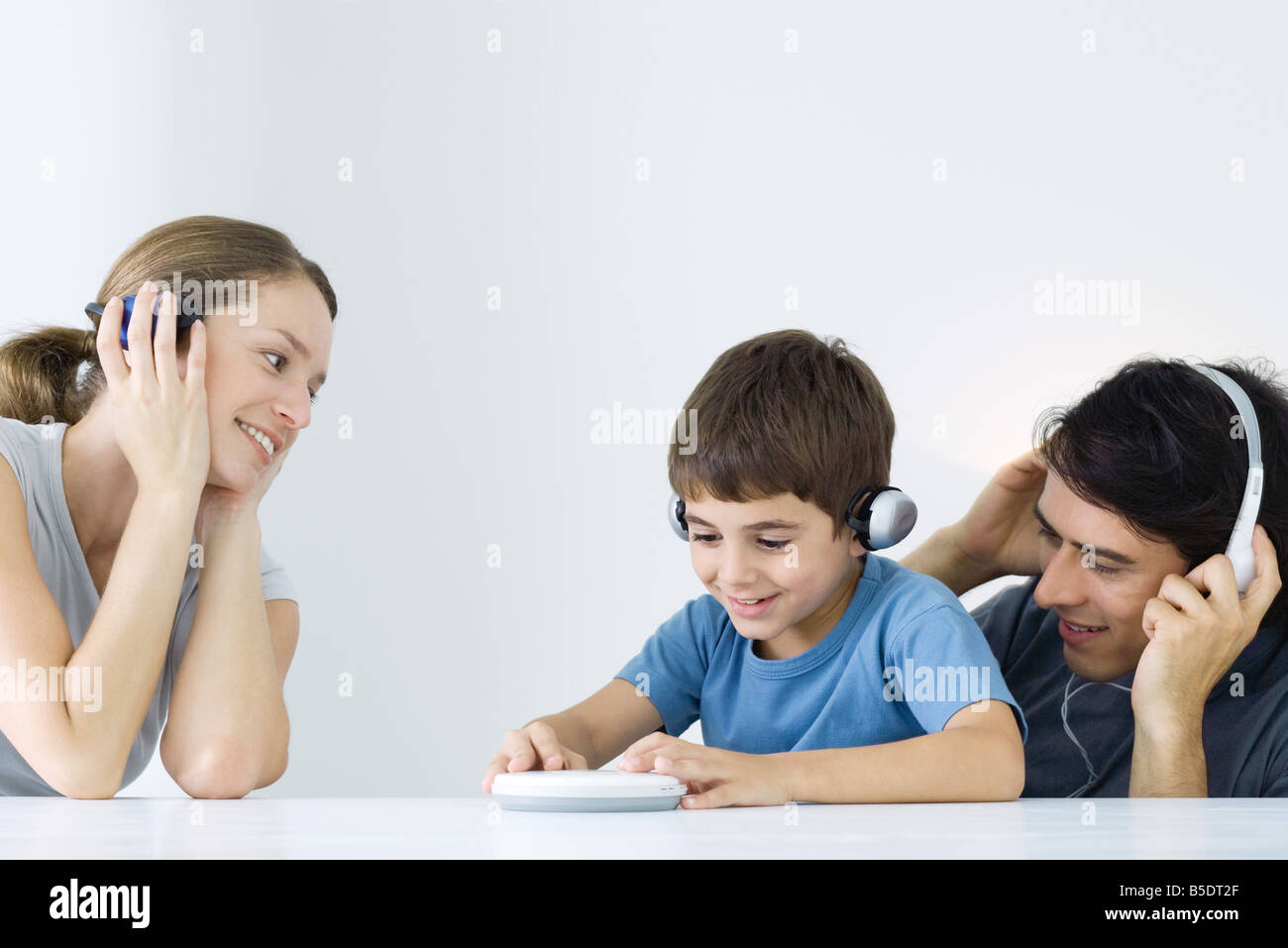 Family listening to portable CD player together Stock Photo - Alamy