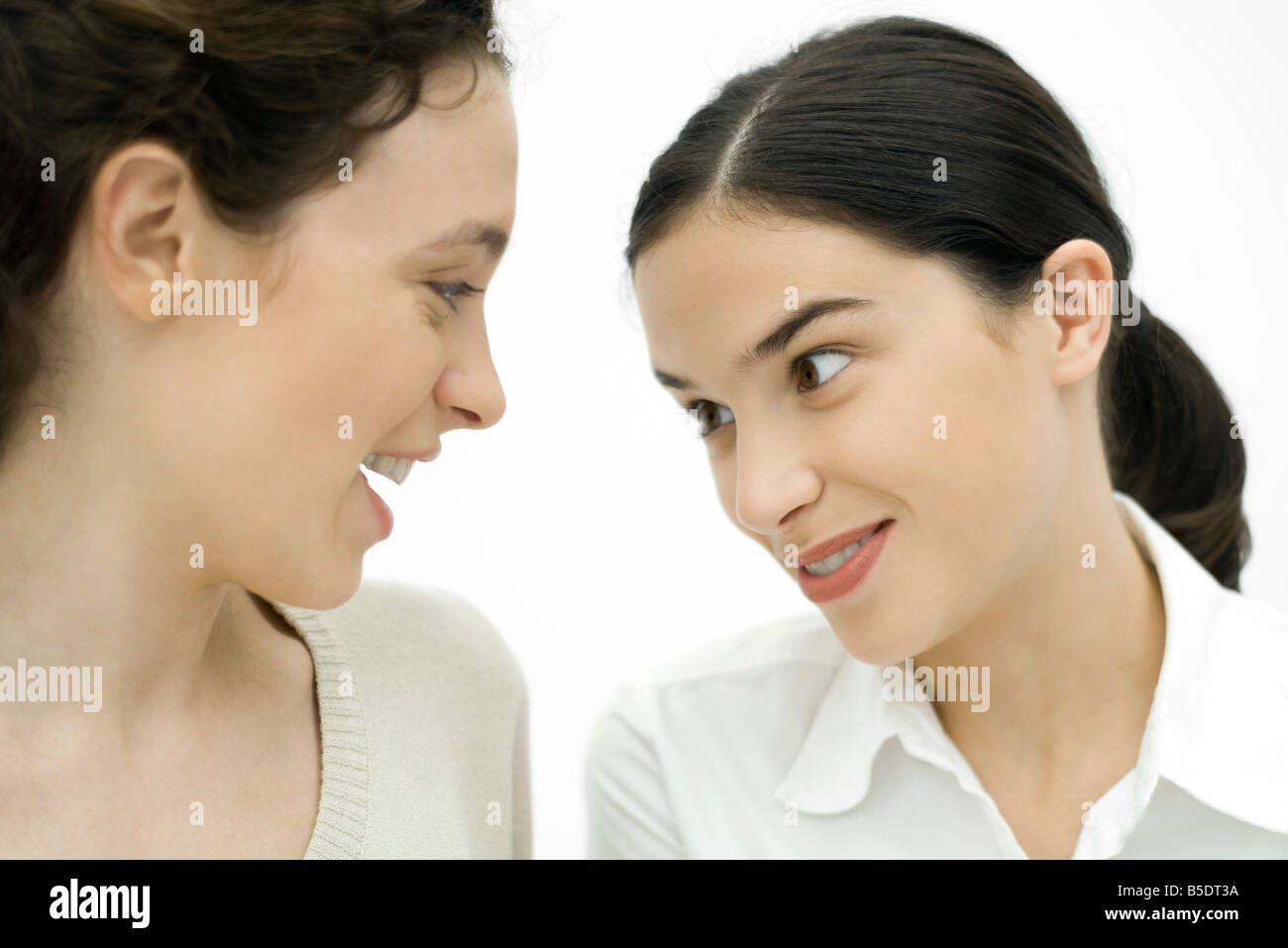 Two young women face to face, smiling, close-up Stock Photo - Alamy
