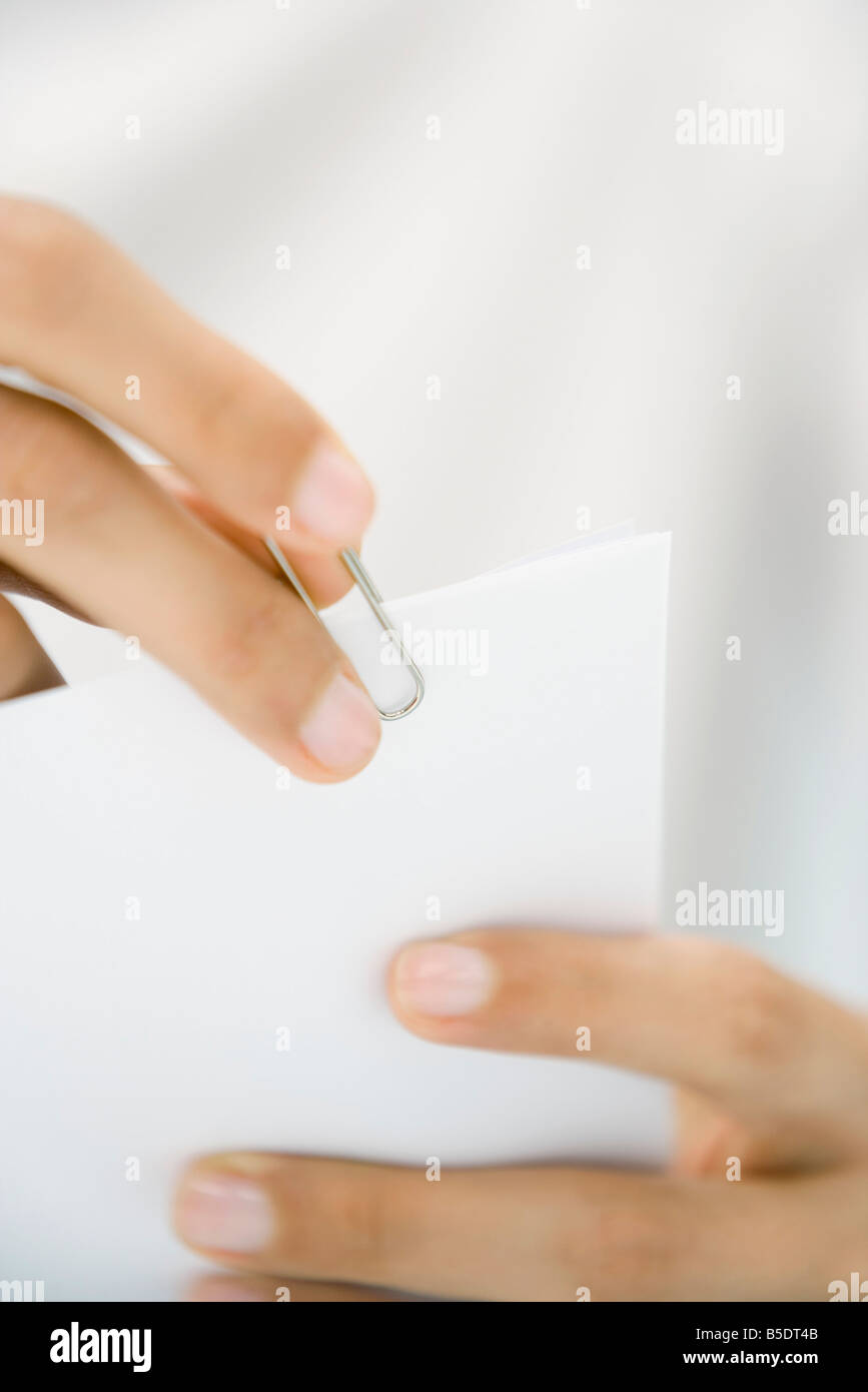 Hands putting paperclip on document, close-up Stock Photo - Alamy