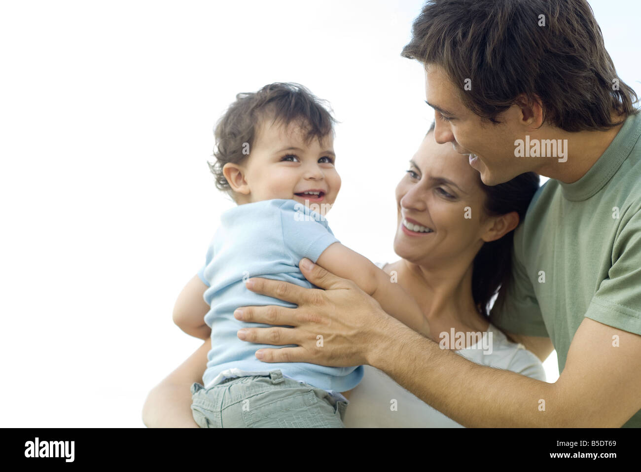 Parents embracing toddler, all smiling Stock Photo - Alamy