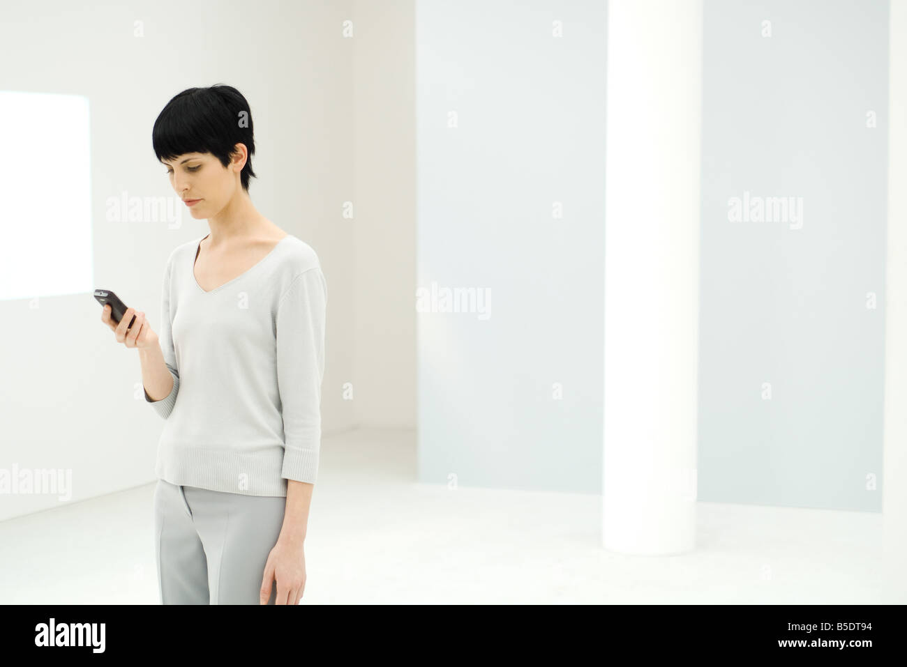 Professional woman looking at cell phone Stock Photo - Alamy