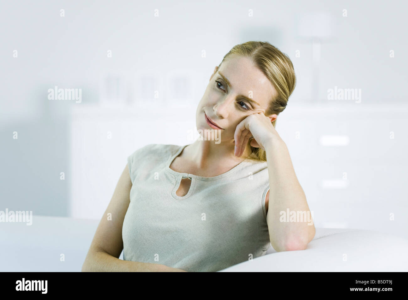 Woman leaning on elbow, looking away Stock Photo - Alamy