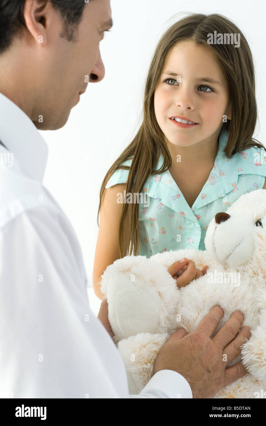 Pediatrician with young patient, girl holding teddy bear Stock Photo ... Pediatrician with young patient, girl holding teddy bear Stock Photo ...