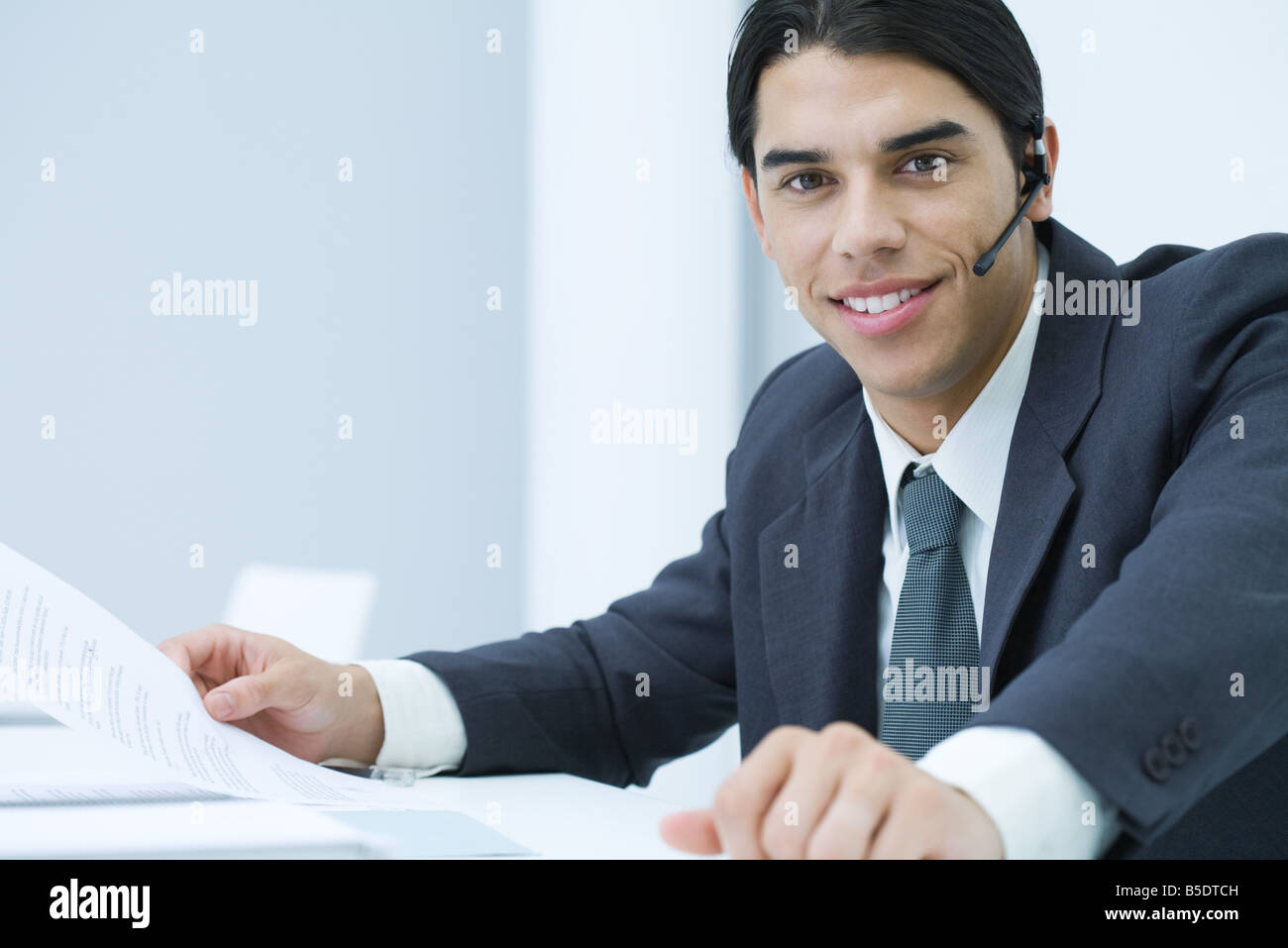 Young professional man wearing headset, smiling at camera, portrait ...