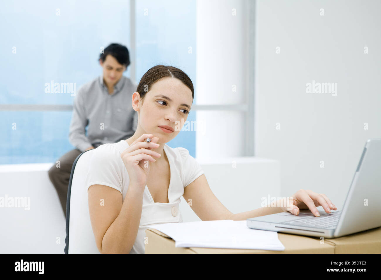 Young woman sitting at makeshift desk, using laptop computer Stock ...