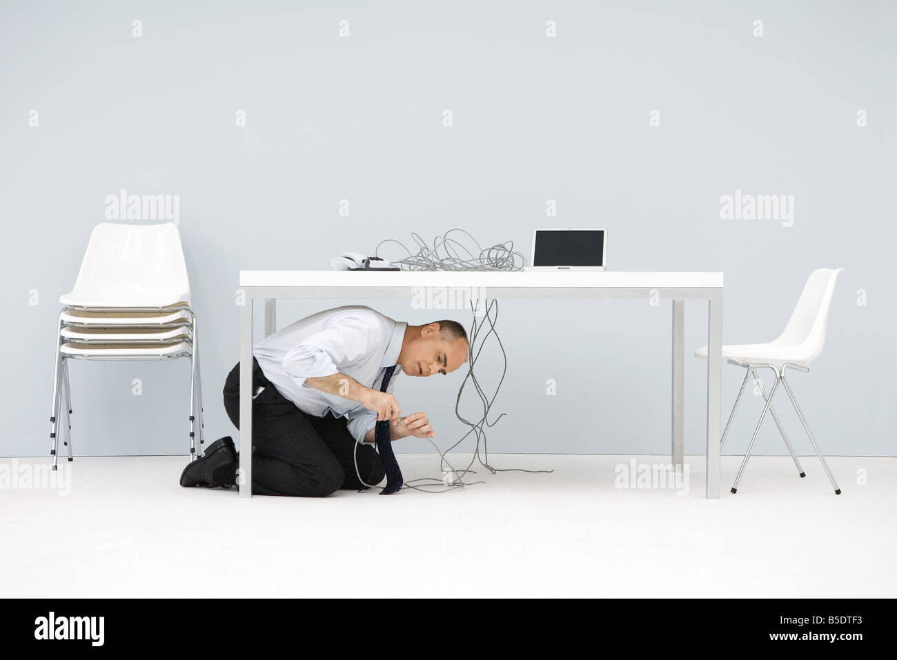 Businessman kneeling under table examining hi-res stock photography and ...