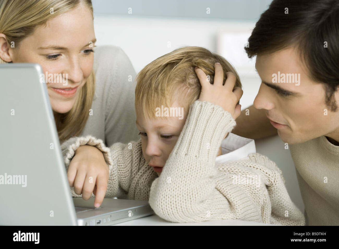 Parents helping little boy use laptop computer, close-up Stock Photo ...