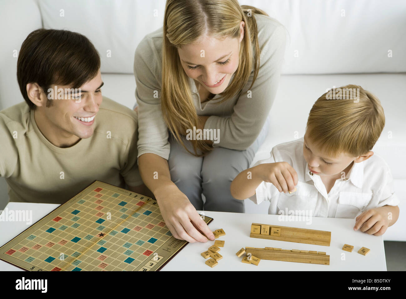 Family playing board game together, mother arranges game pieces Stock ...