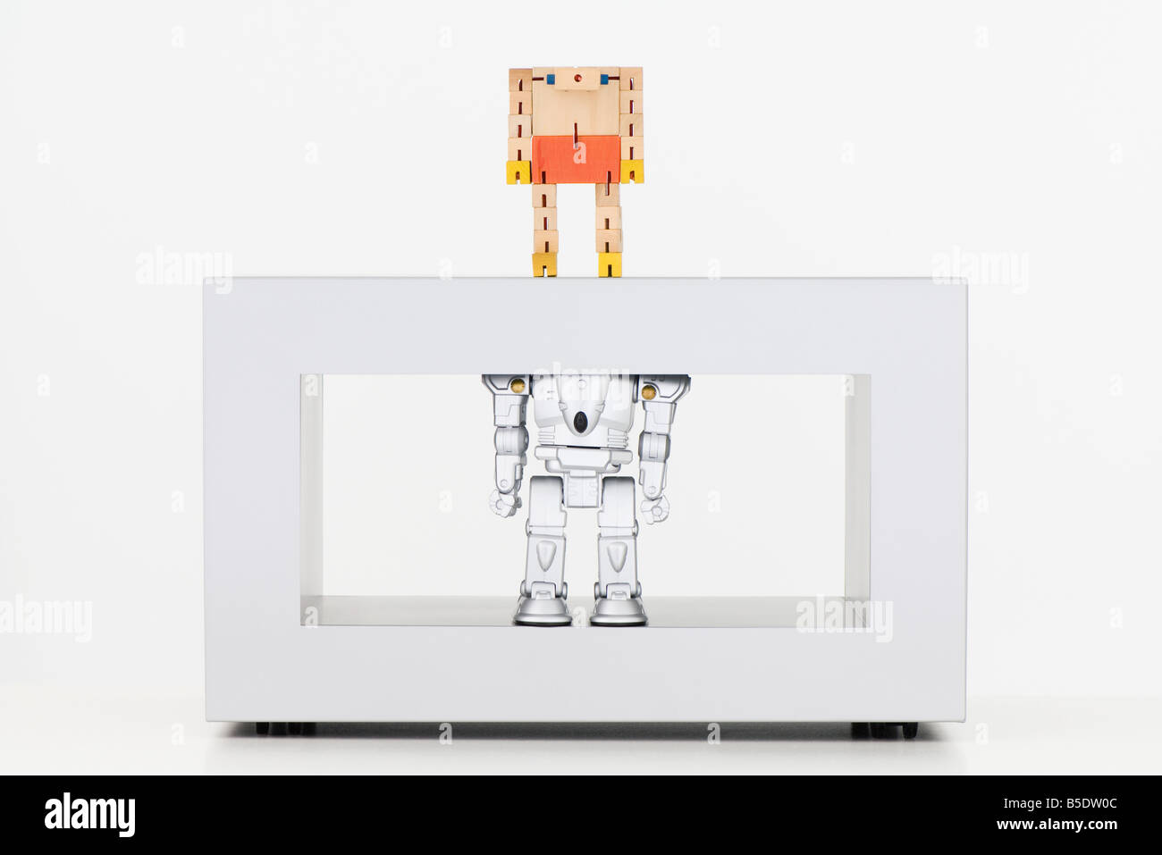 Toy robots standing on coffee table, the one above looking down at the ...