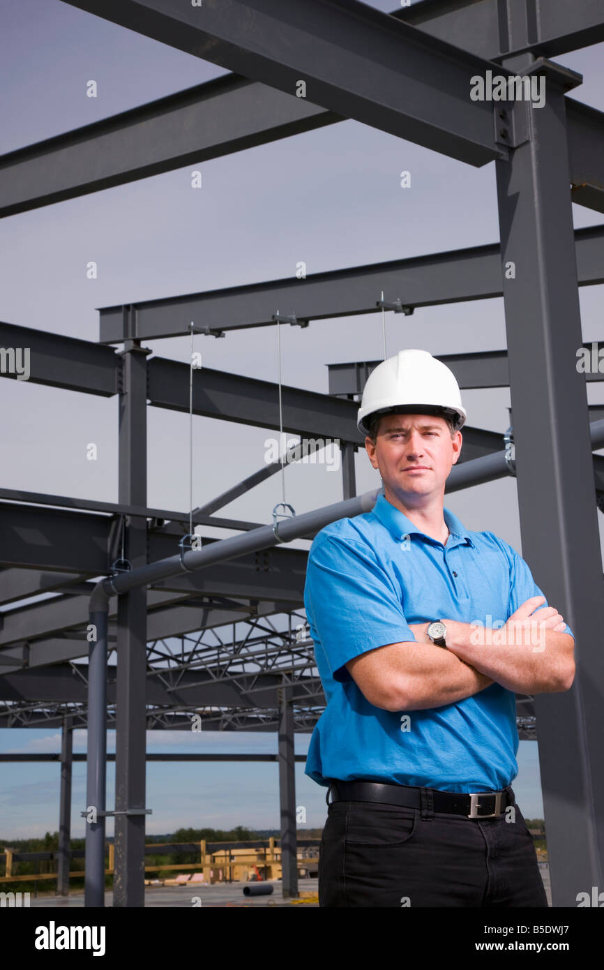 Engineer leaning against metal beam Stock Photo - Alamy