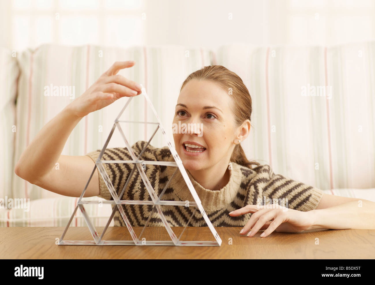 Woman building house cards hi-res stock photography and images - Alamy