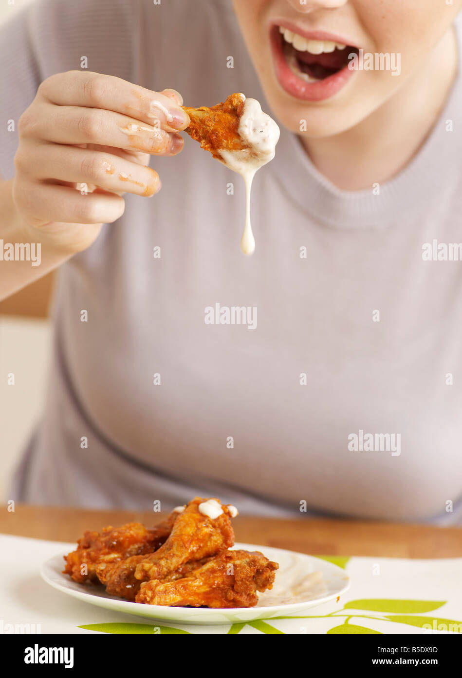 Close-Up of Woman Eating Chicken Legs Stock Photo - Alamy