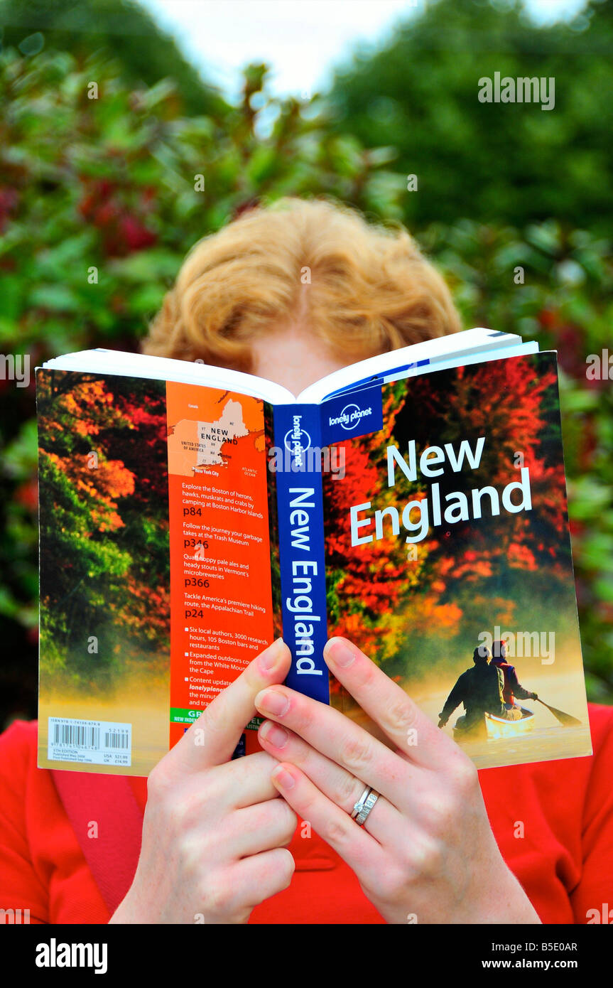 Woman reading a Lonely Planet guidebook, New England, USA Stock Photo ...