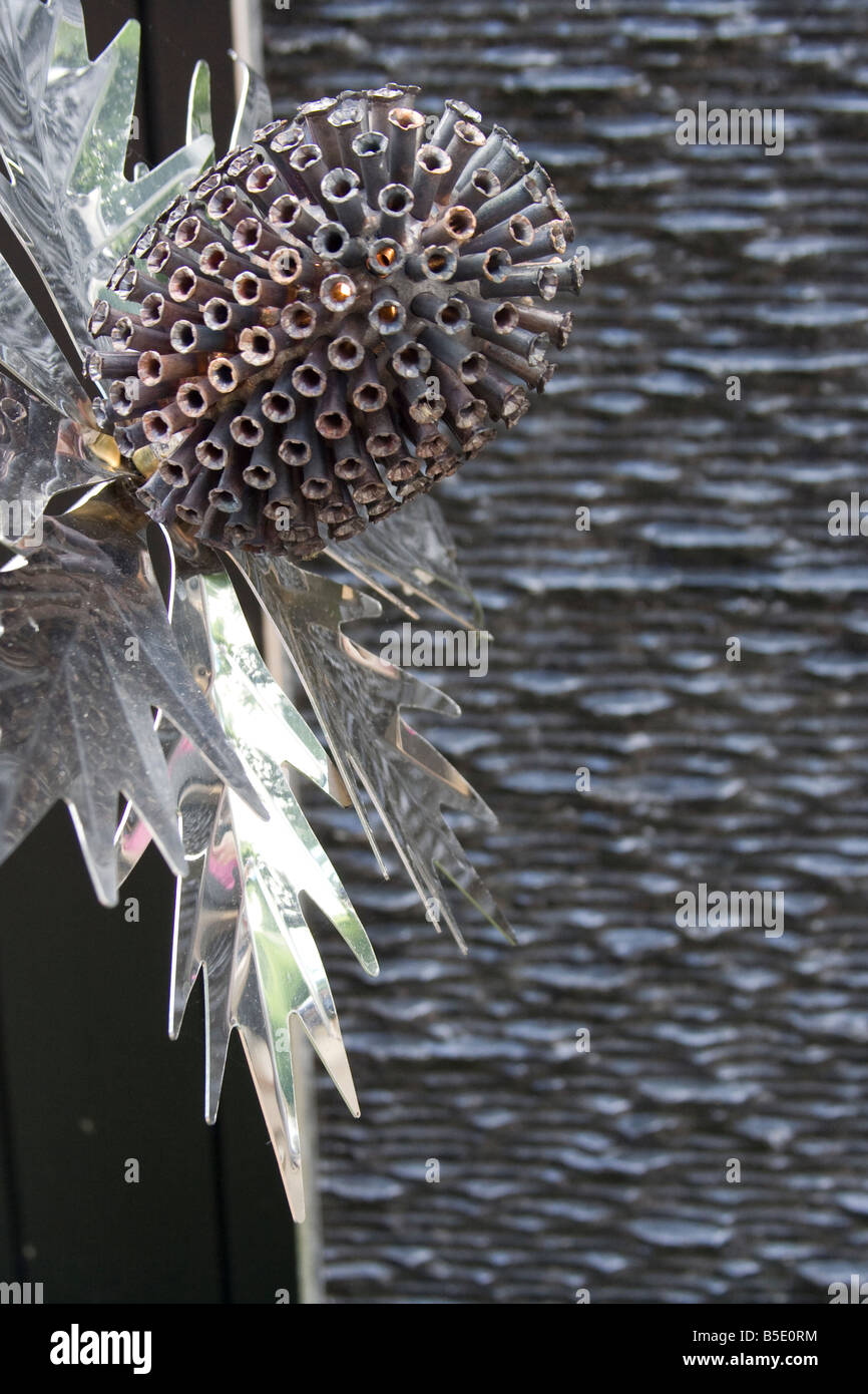 Aluminum sculpture of a thistle against a water feature in the ...