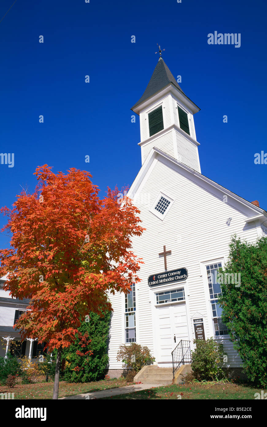 A small maple tree in fall colours before the Center Conway United ...