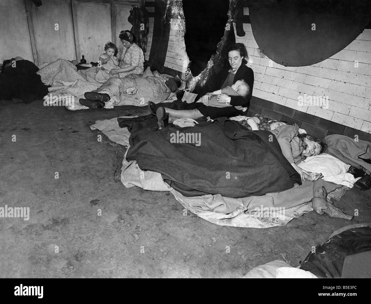 Woman feeding her baby in an underground tube station used as an air ...