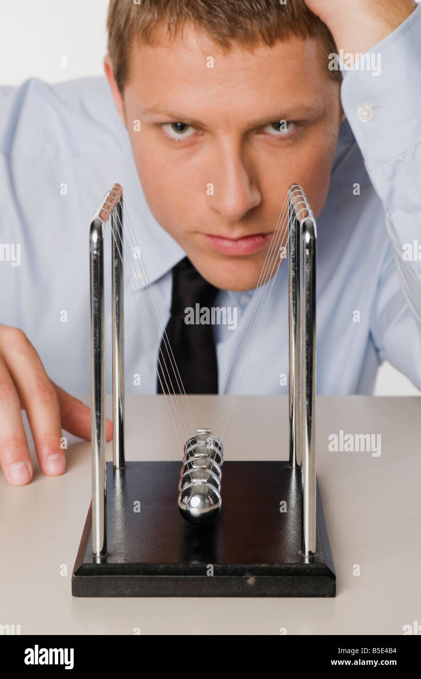 Businessman watching newtons cradle hi-res stock photography and images ...