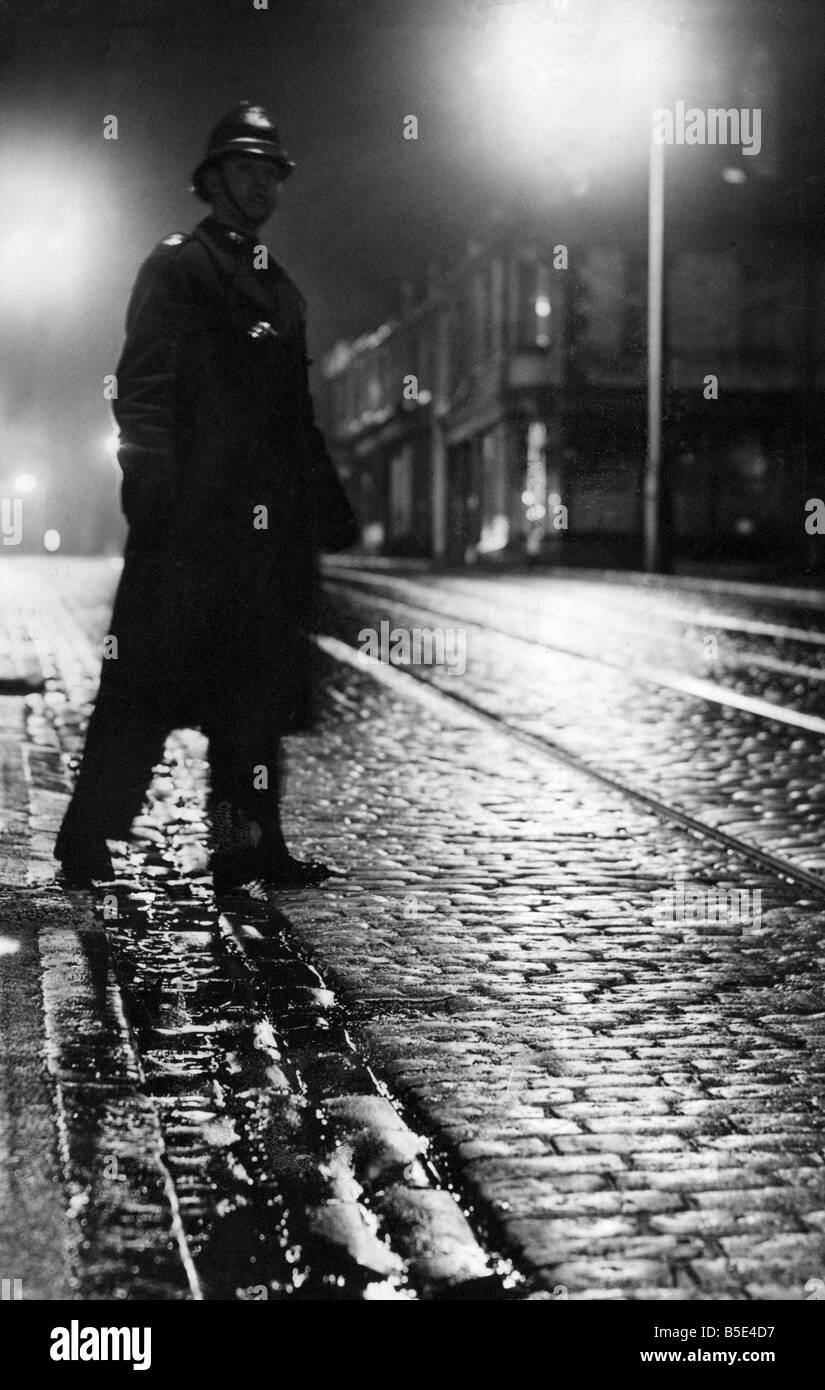 A lone police officer on beat during the night shift Stock Photo - Alamy