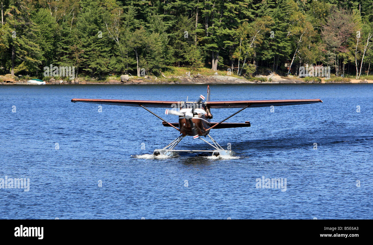 A single engine float plane taxing to the dock on Long Lake New York ...