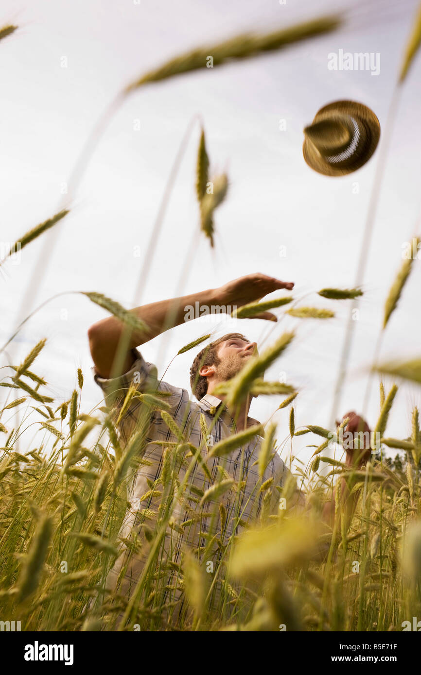 Farmer throwing hat in field Stock Photo - Alamy