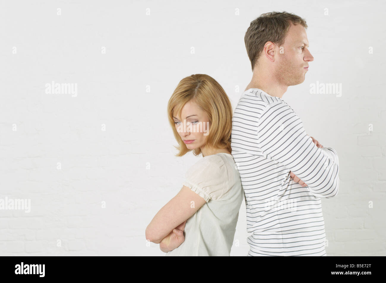 Frustrated couple standing back to back Stock Photo - Alamy