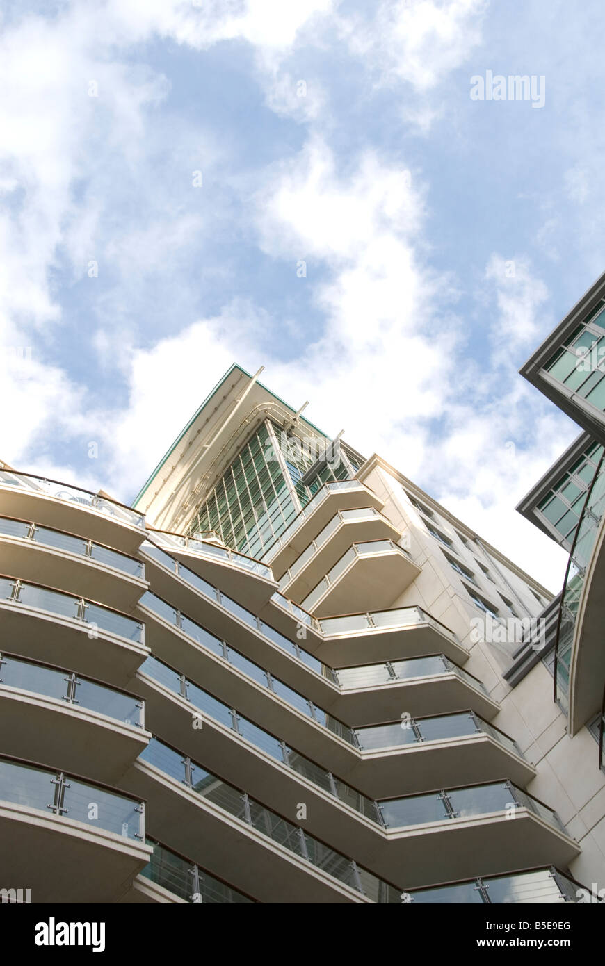 An image looking up at a modern block of london flats with blue sky an ...