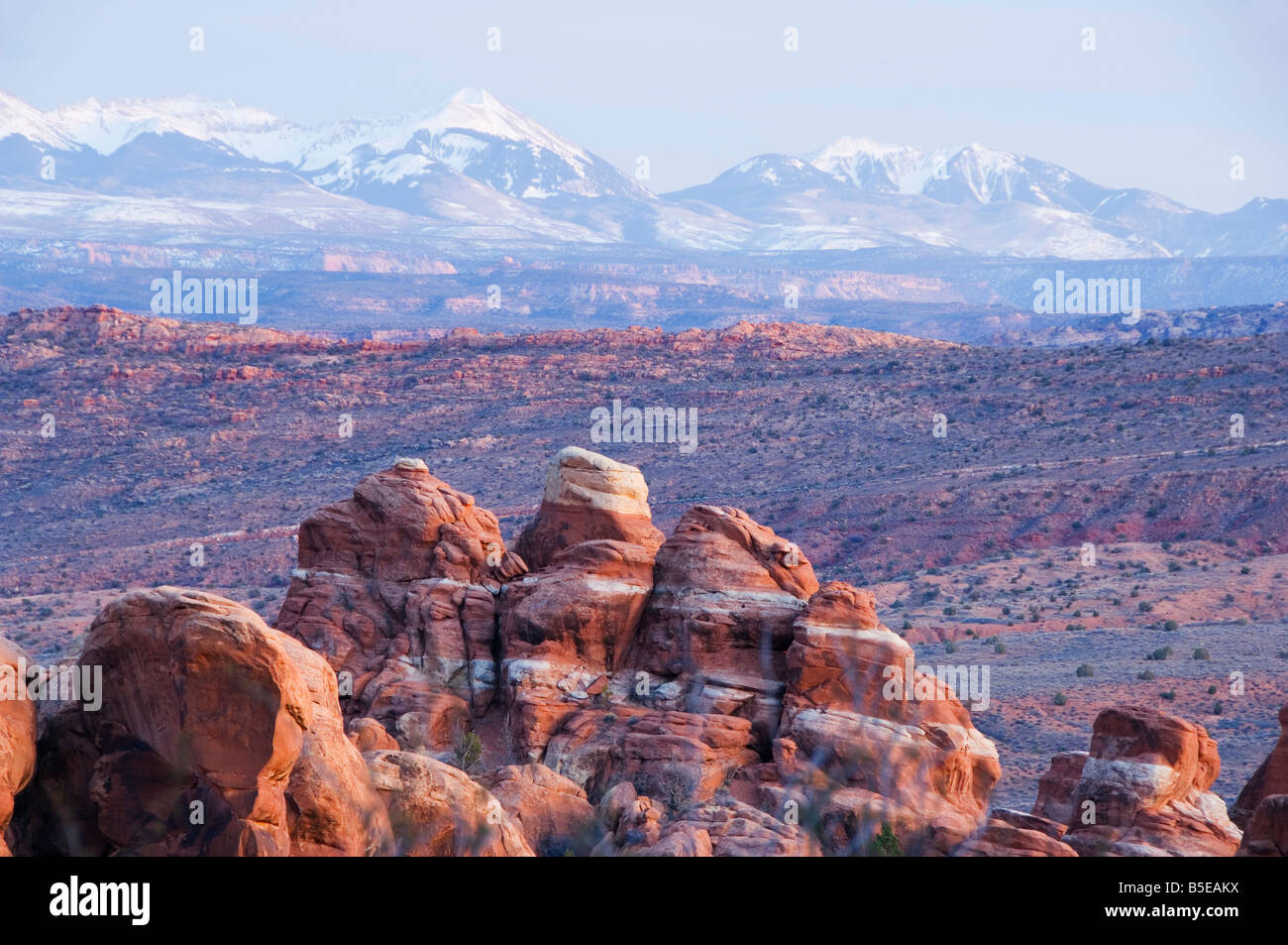 Rock formations at the Fiery Furnace, and snow capped mountains of ...