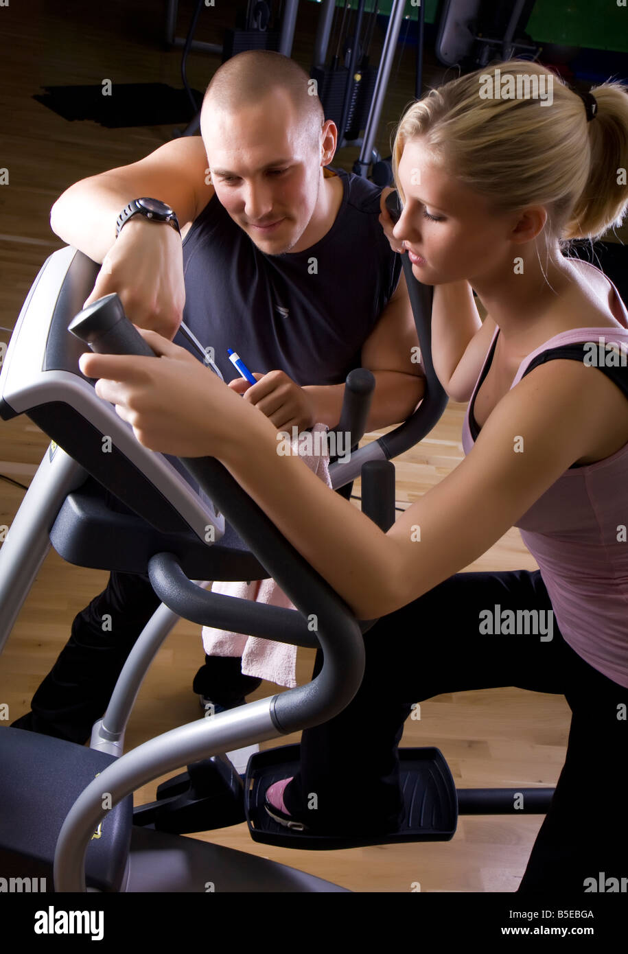 trainer with young woman on Stairmaster Stock Photo - Alamy