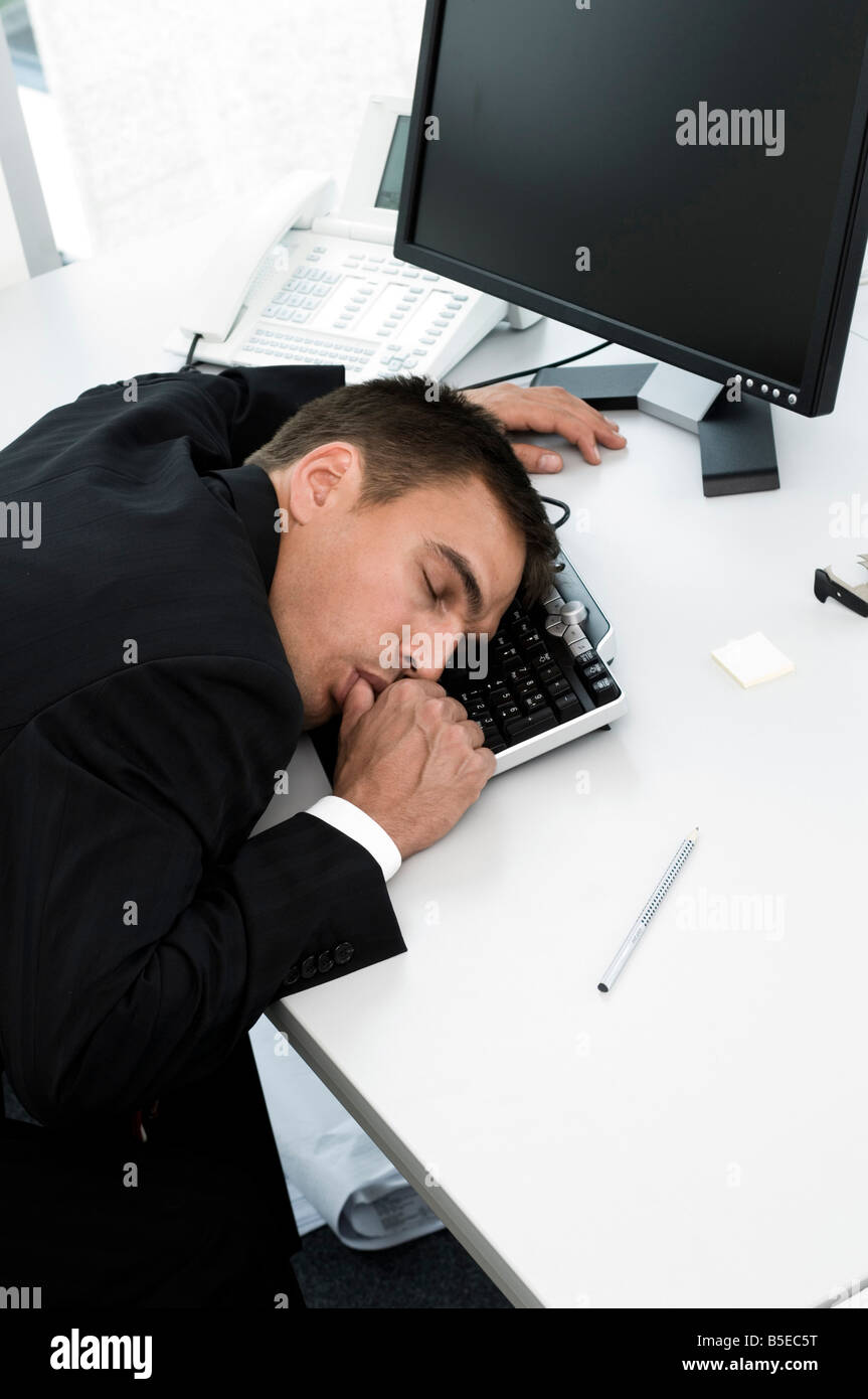Businessman sleeping at workplace, elevated view Stock Photo - Alamy