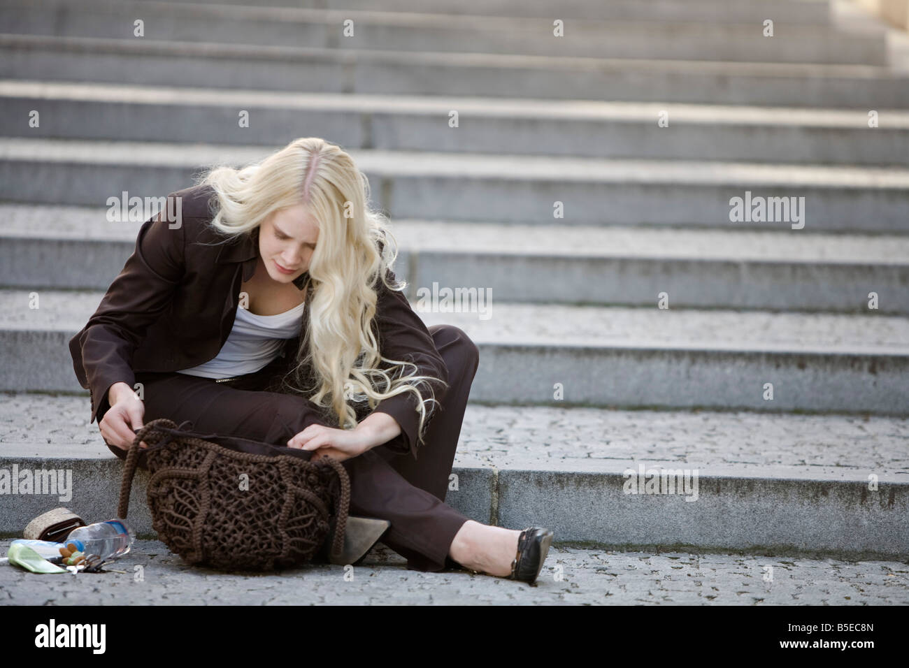 Young woman seeking for something in handbag Stock Photo - Alamy