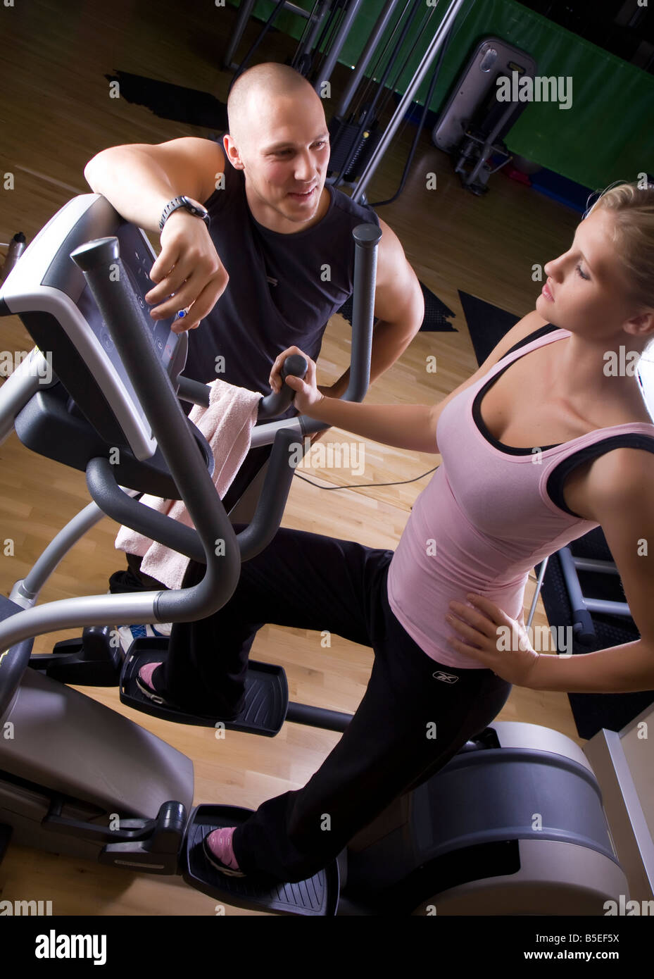 trainer with young woman on Stairmaster Stock Photo - Alamy