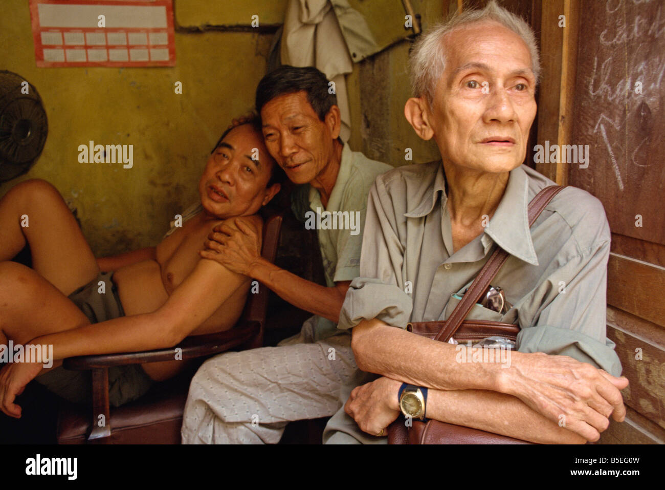 Portrait of three men a shoe maker and mender in Vietnam Asia T Hall ...