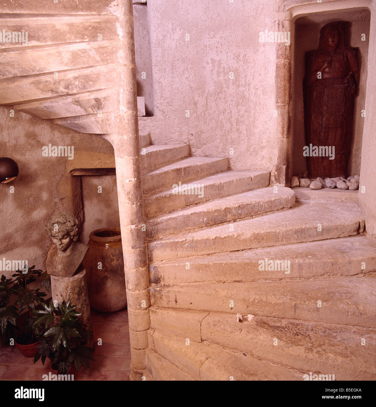 Statue in alcove above medieval stone spiral staircase Stock Photo - Alamy