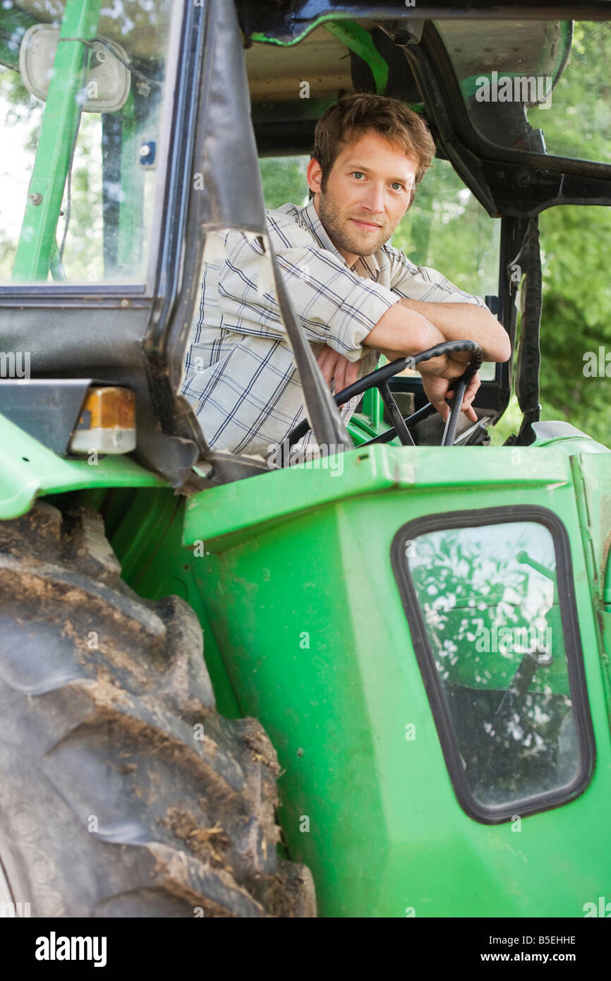 Farmer sitting on tractor Stock Photo - Alamy