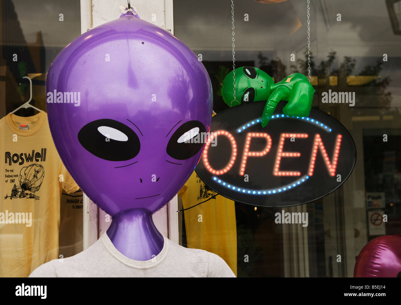 Purple inflatable alien guarding the shop door Stock Photo - Alamy
